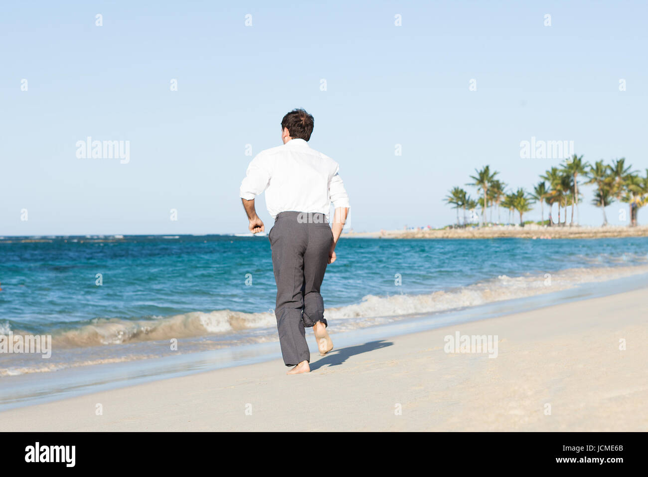 Full length rear view of excited man running towards sea at beach Stock ...