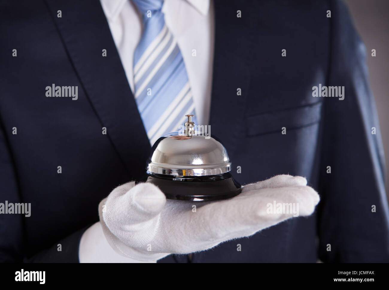 Midsection of bellman holding bell against black background Stock Photo ...