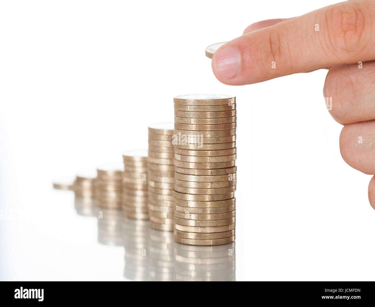 Cropped image of man stacking coins at desk against white background ...