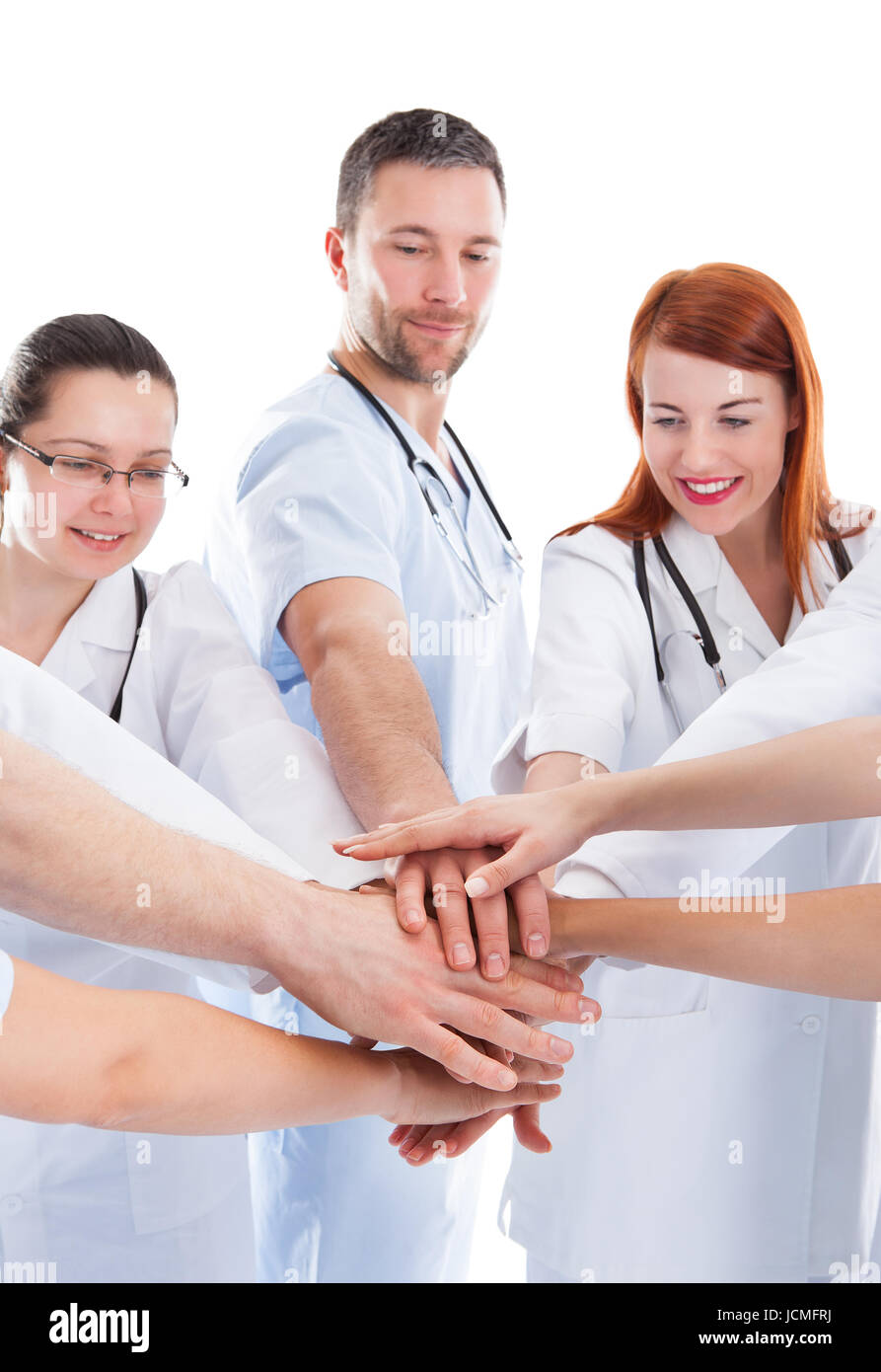 Doctors and nurses in a medical team stacking hands in a show of ...