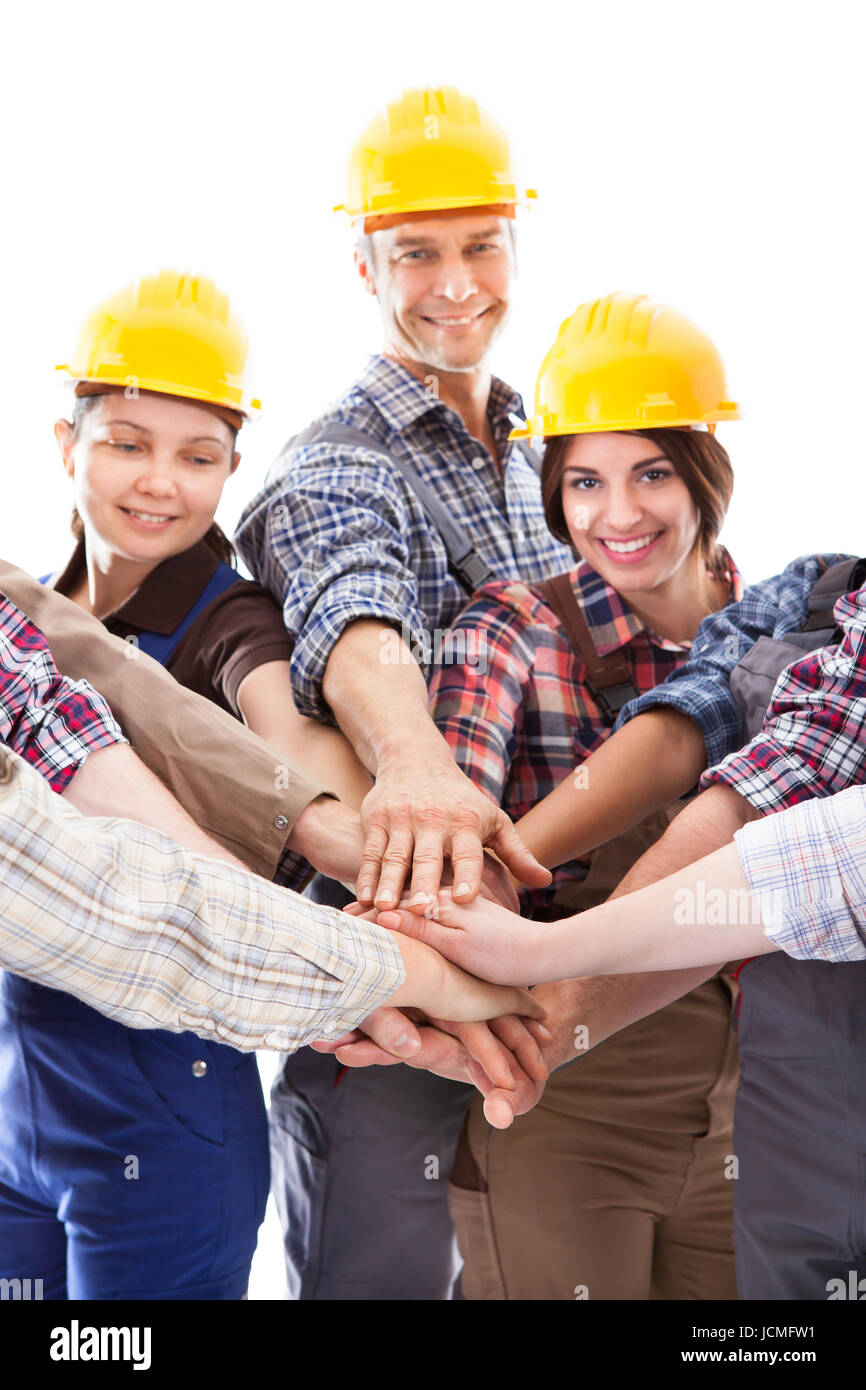 Diverse group of construction workers stacking hands. Isolated on white ...