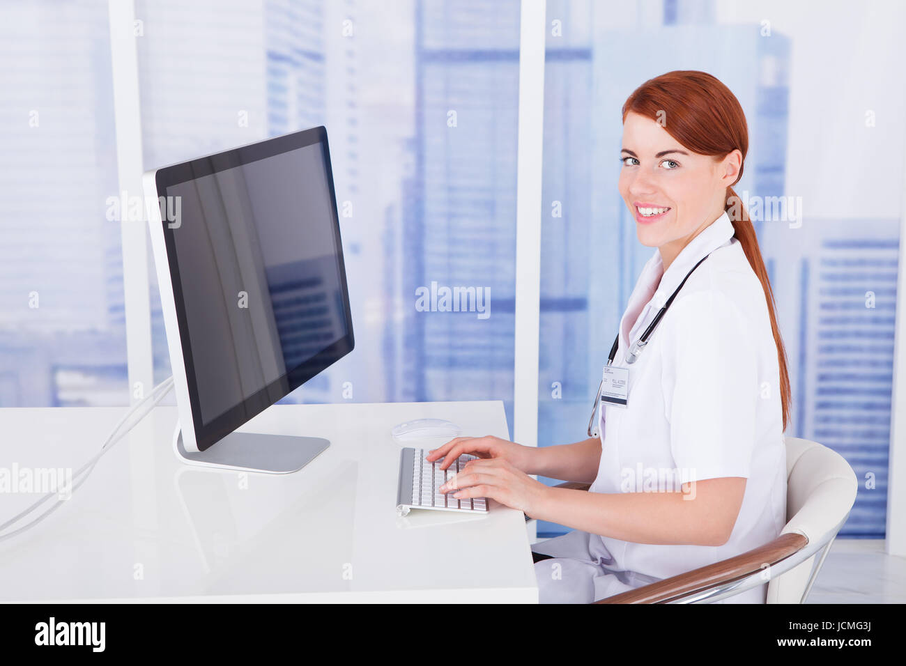 Portrait of young female doctor using computer at desk in clinic Stock ...