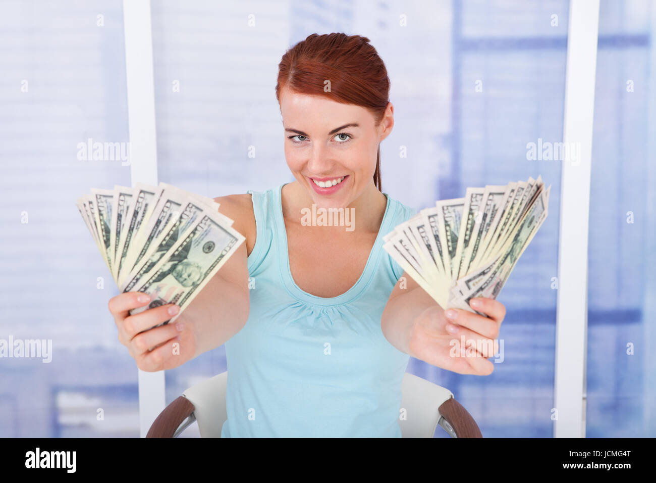 Portrait of beautiful young woman showing dollar bills at home Stock ...