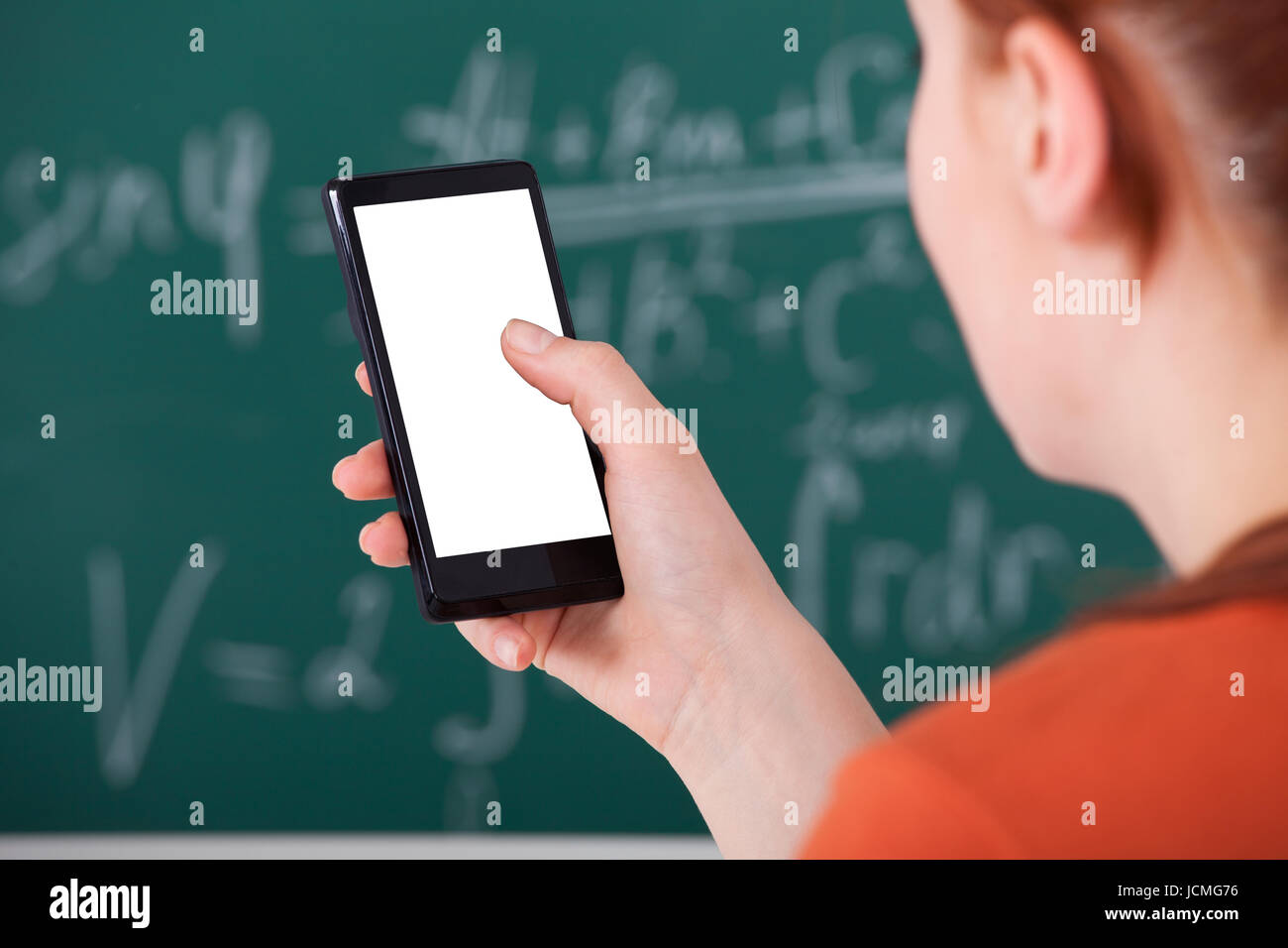Cropped image of female college student using smart phone in classroom ...