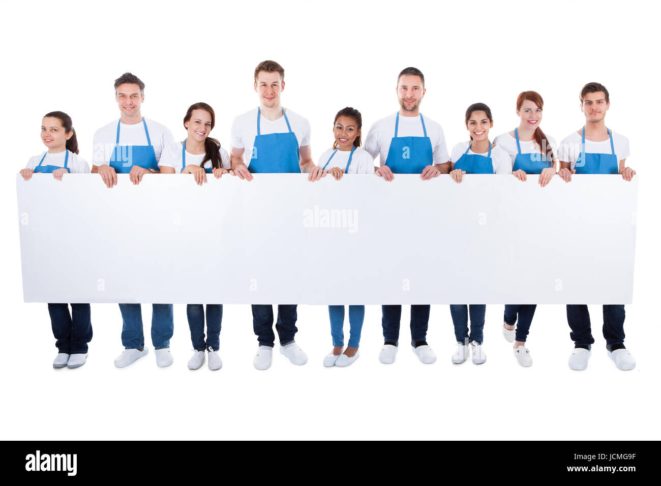 Large diverse group of cleaners or janitors wearing aprons holding a ...
