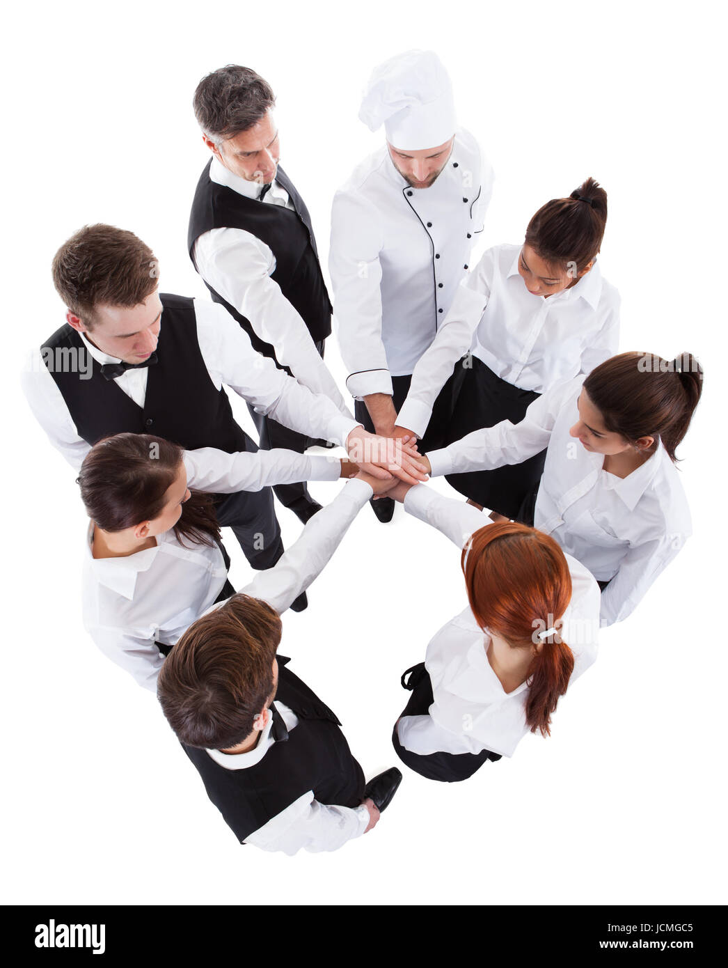 High angle view of waiters and waitresses stacking hands. Isolated on ...