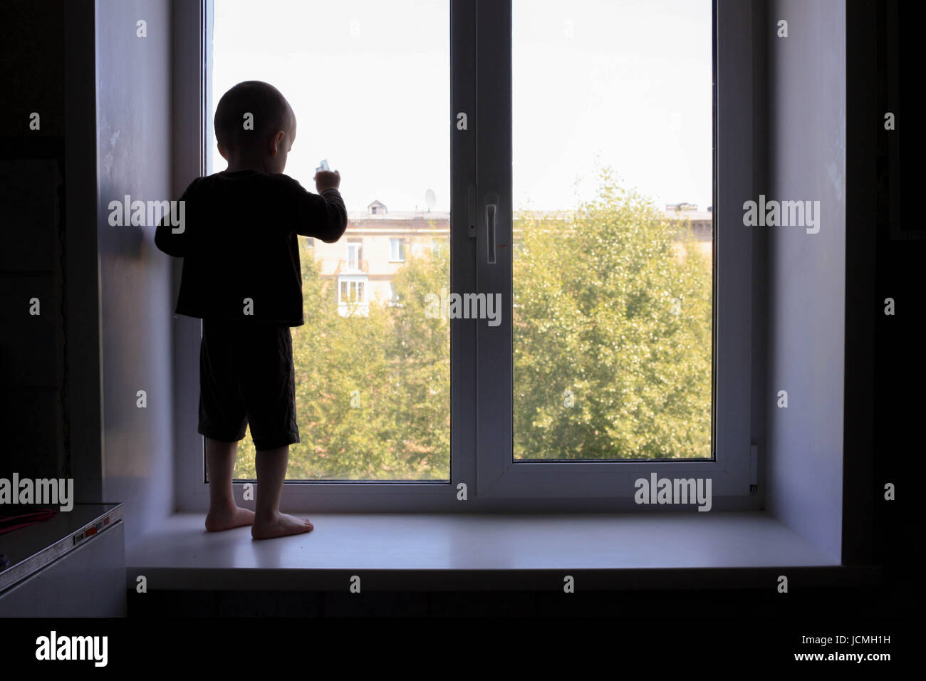Crisis child concept. The child looks out the window. Photo for your ...