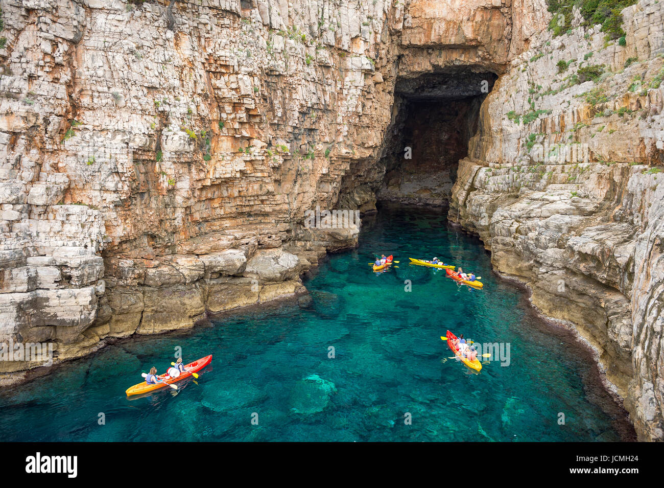 View from the rock cliffs of kayakers exploring the crystal clear ...