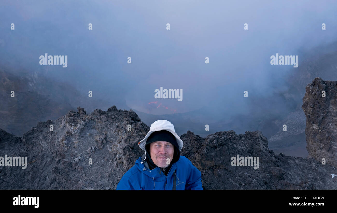 Tourist on the crater rim of Nyiragongo Volcano and its lava lake in ...