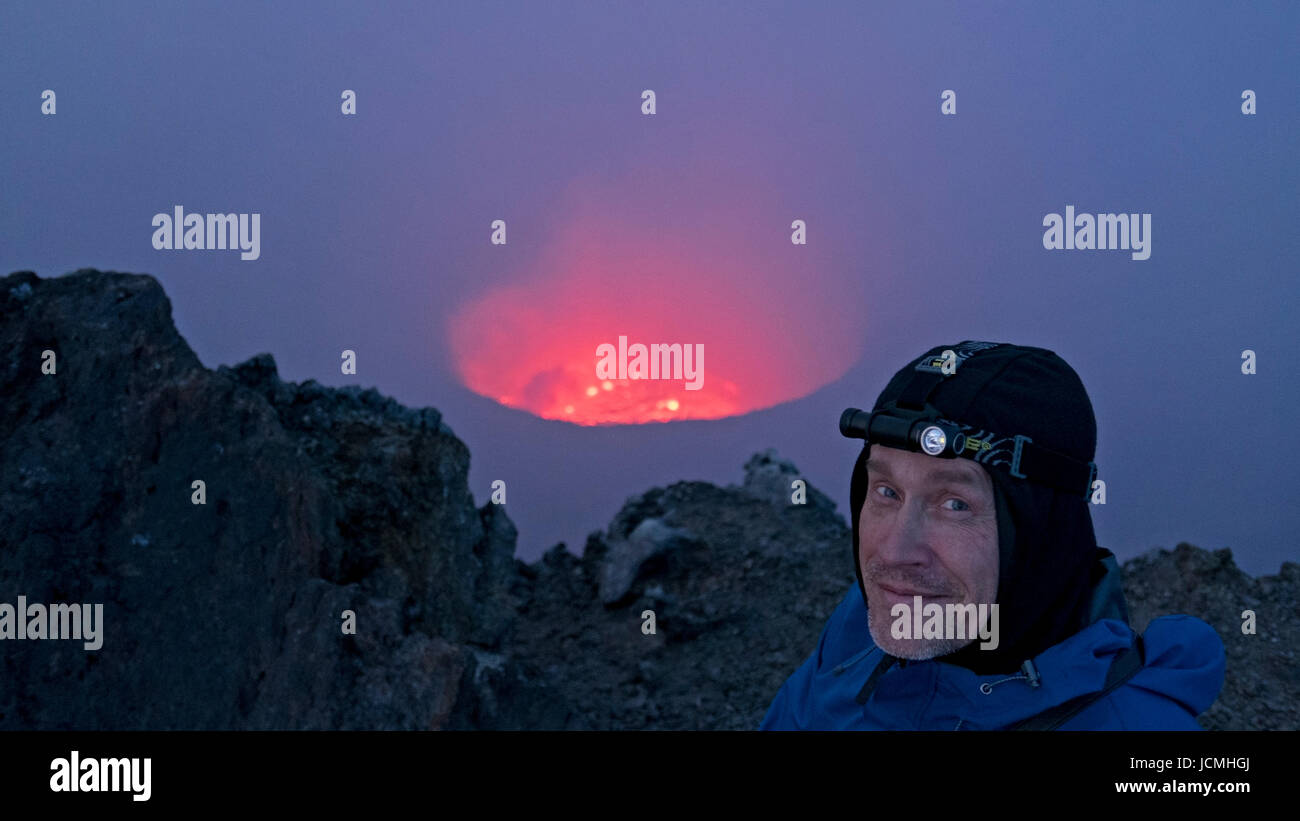 Tourist on the crater rim of Nyiragongo Volcano and its lava lake in ...