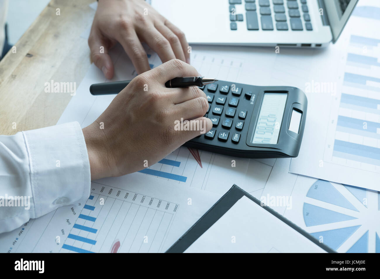 young businessman working with calculator, business document and laptop ...
