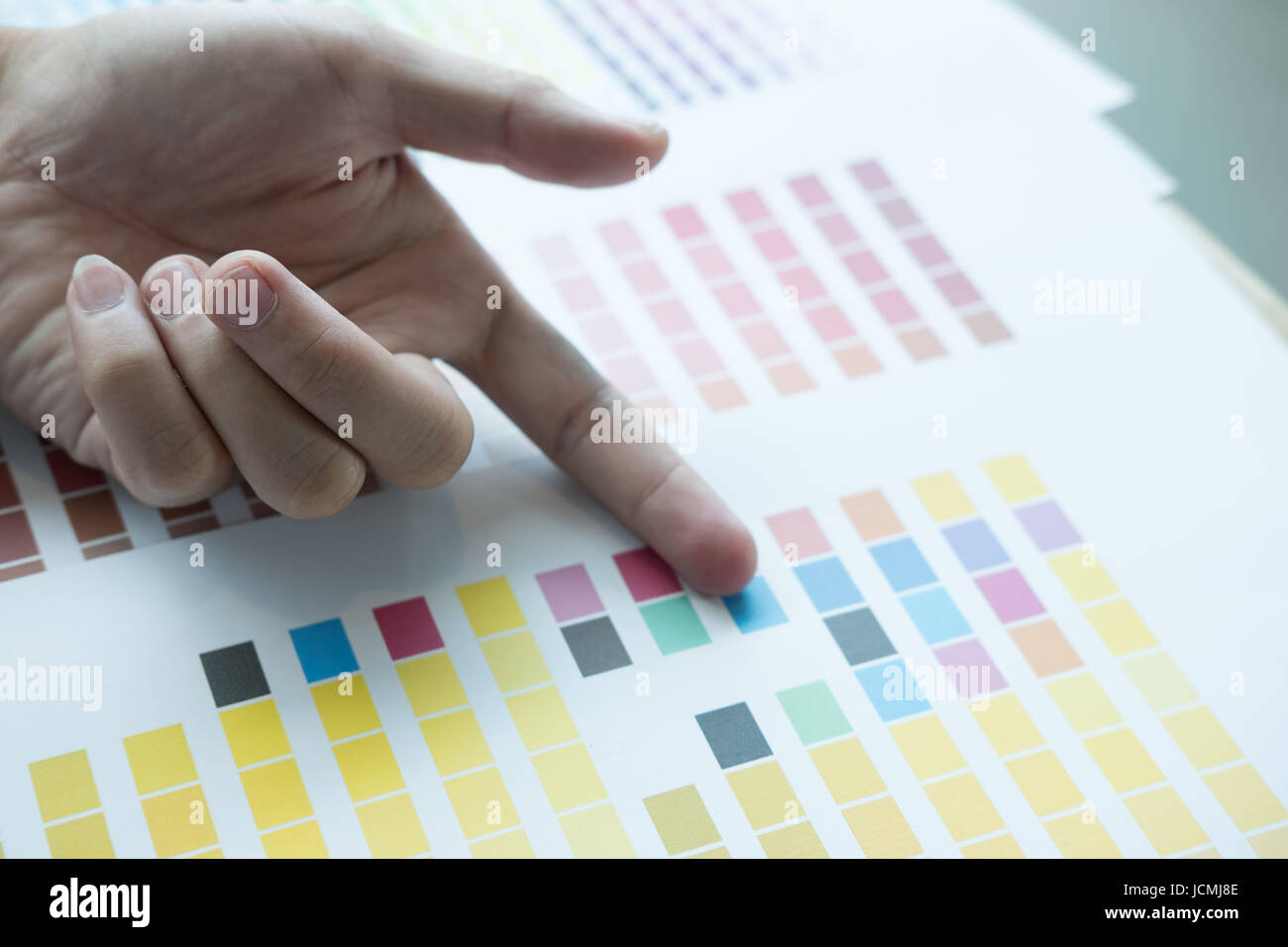 young male graphic designer working with color swatch at modern office ...