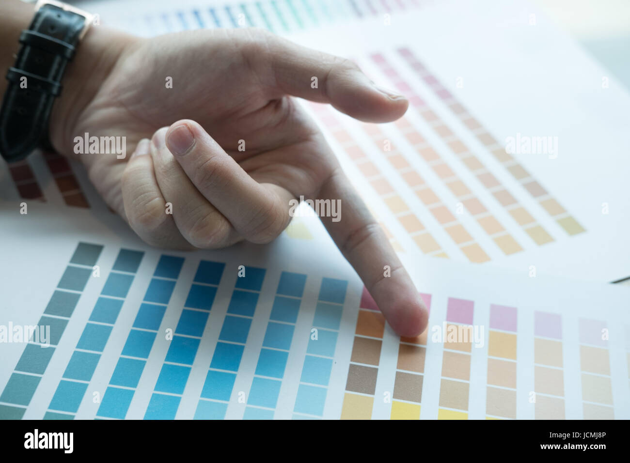 young male graphic designer working with color swatch at modern office ...