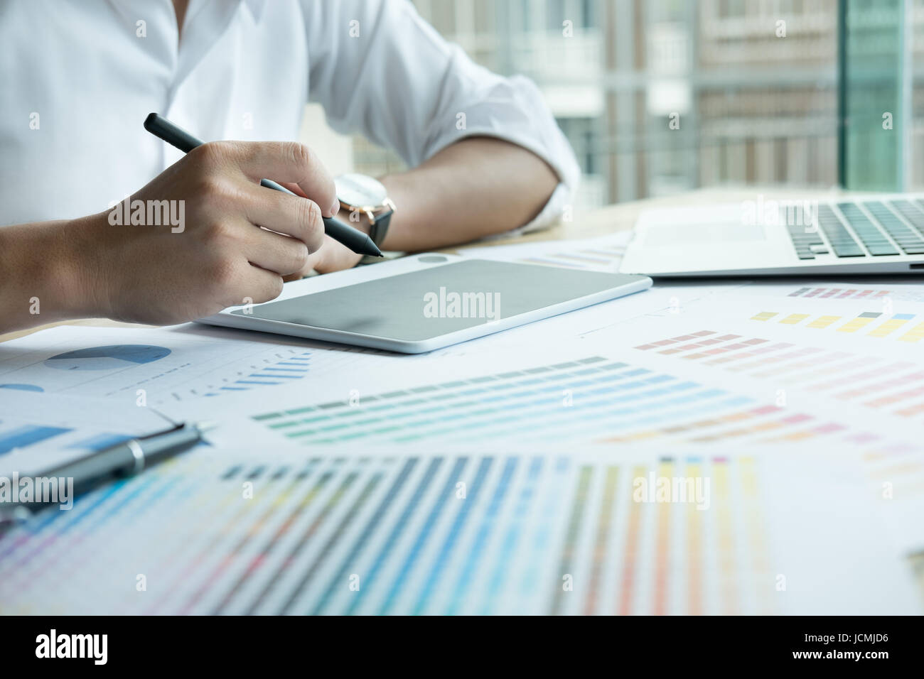 young male graphic designer working with computer and color swatch ...