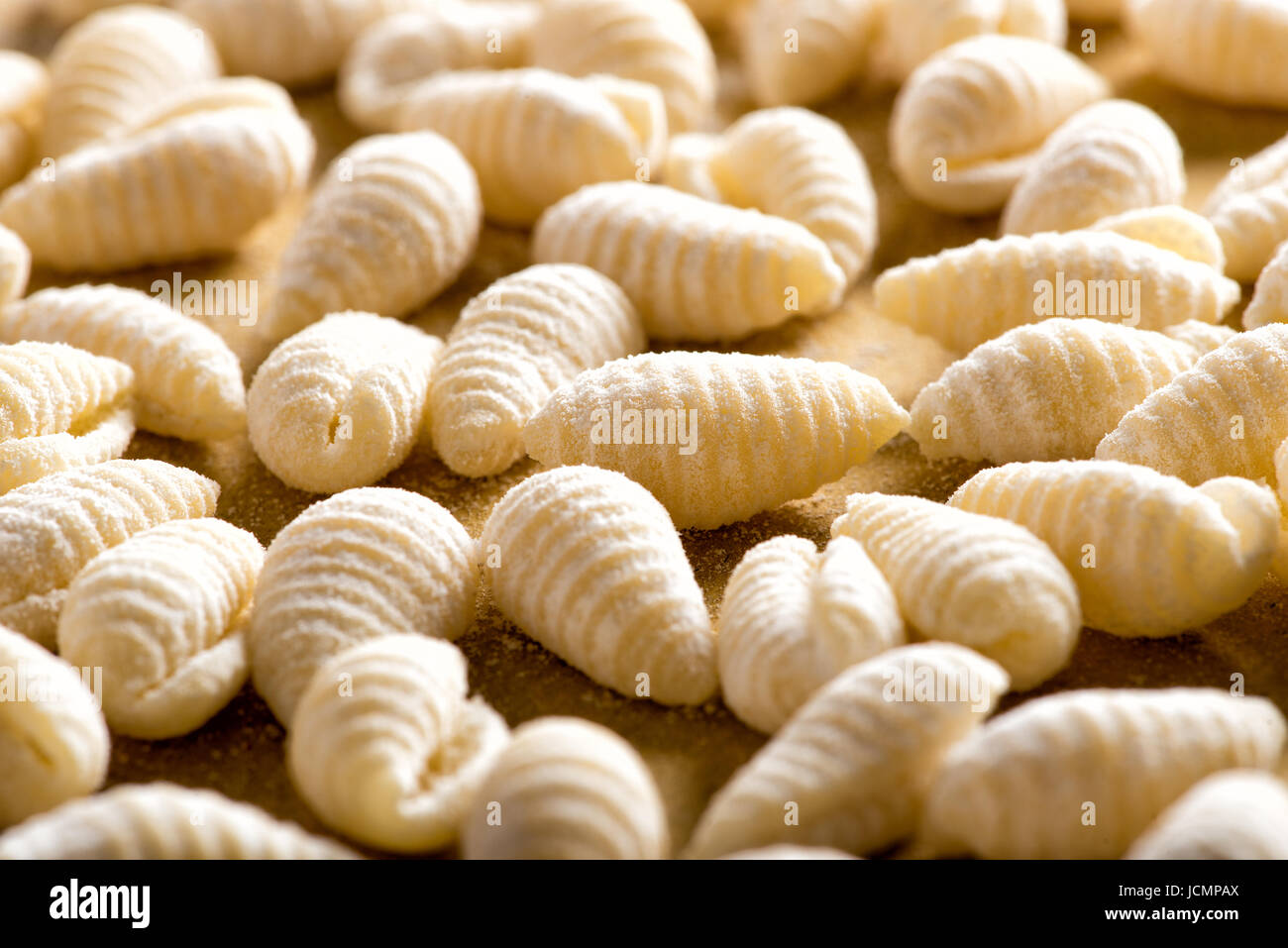 Close-up of uncooked shells shape handmade Italian pasta on wooden ...