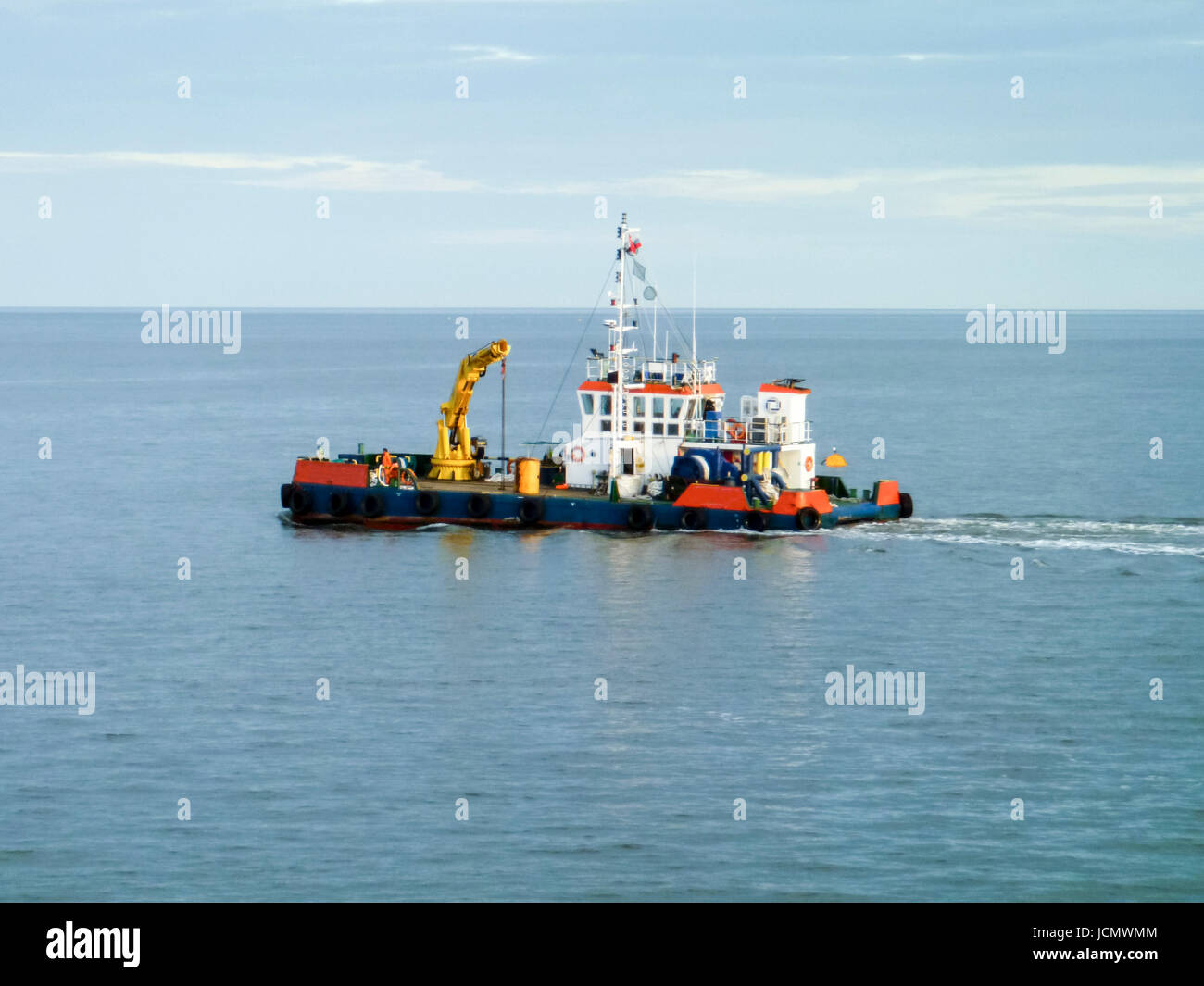 A small service ship in a cargo industrial port. A ship in the sea ...