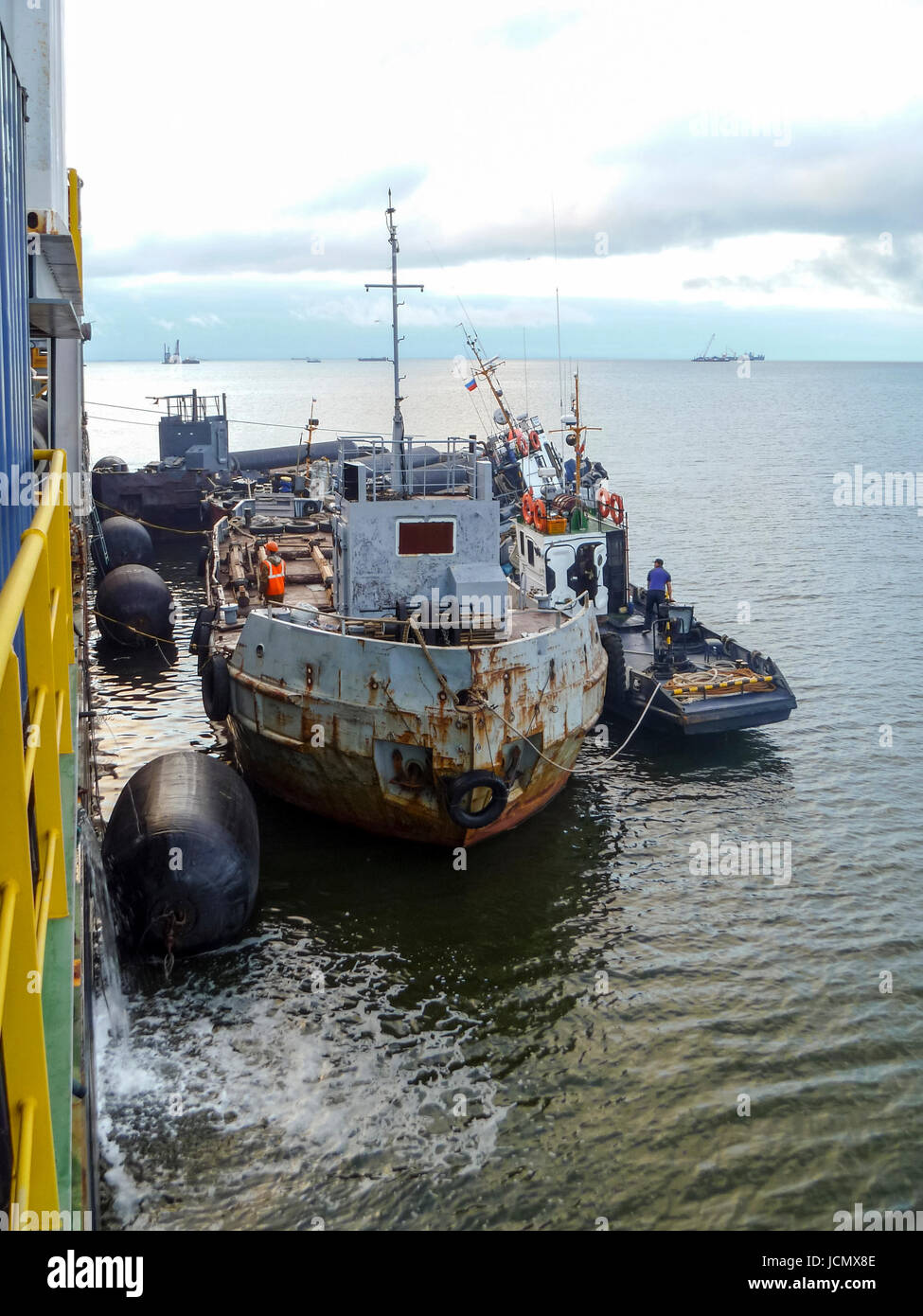 A small service ship in a cargo industrial port. A ship in the sea ...