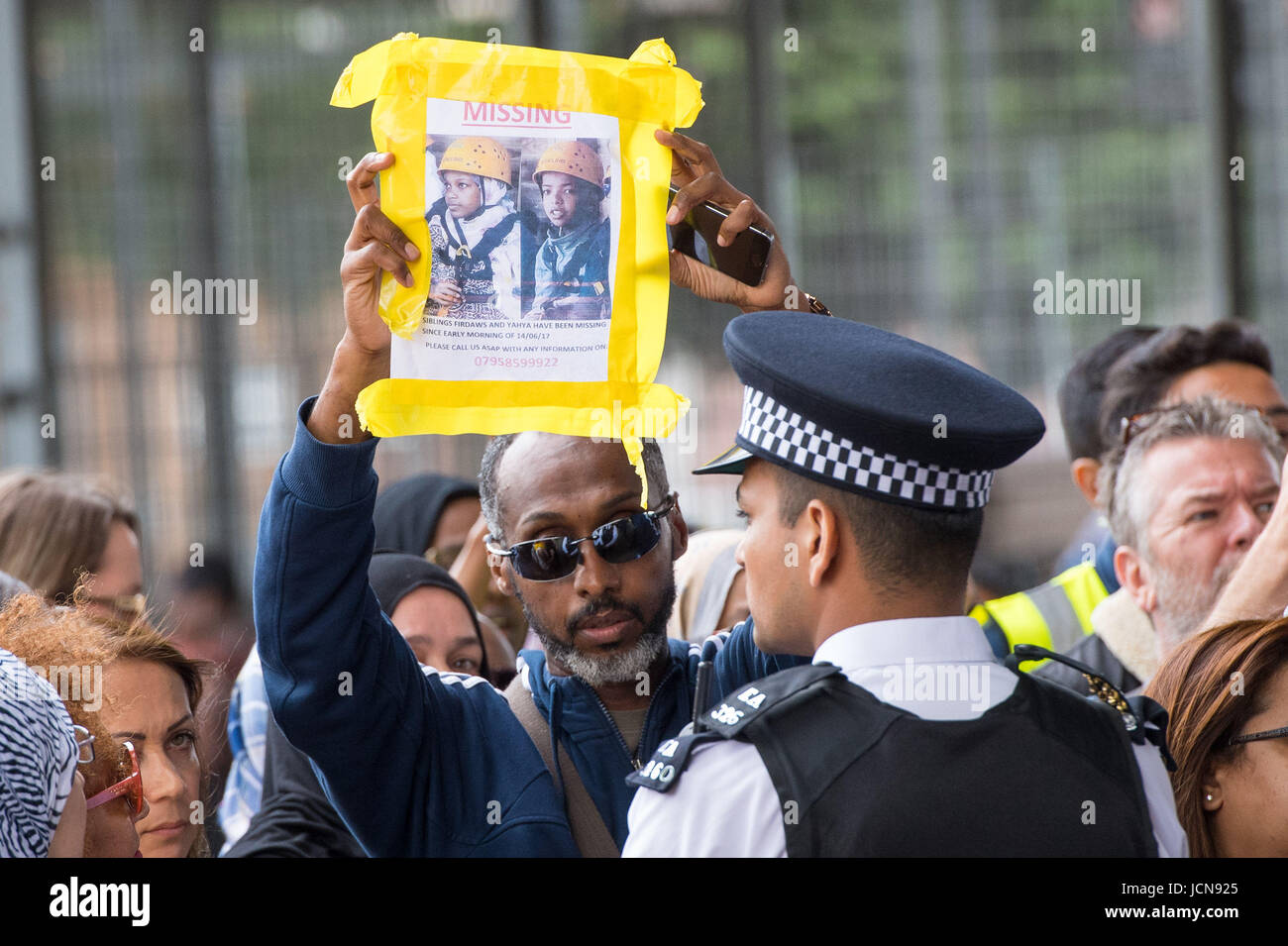 A man hold up a missing persons poster during a visit by Queen ...