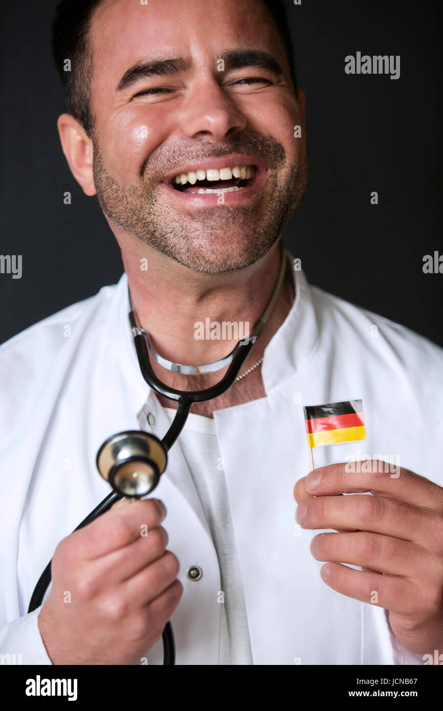 portrait of handsome doctor holding a german flag and smiles Stock ...