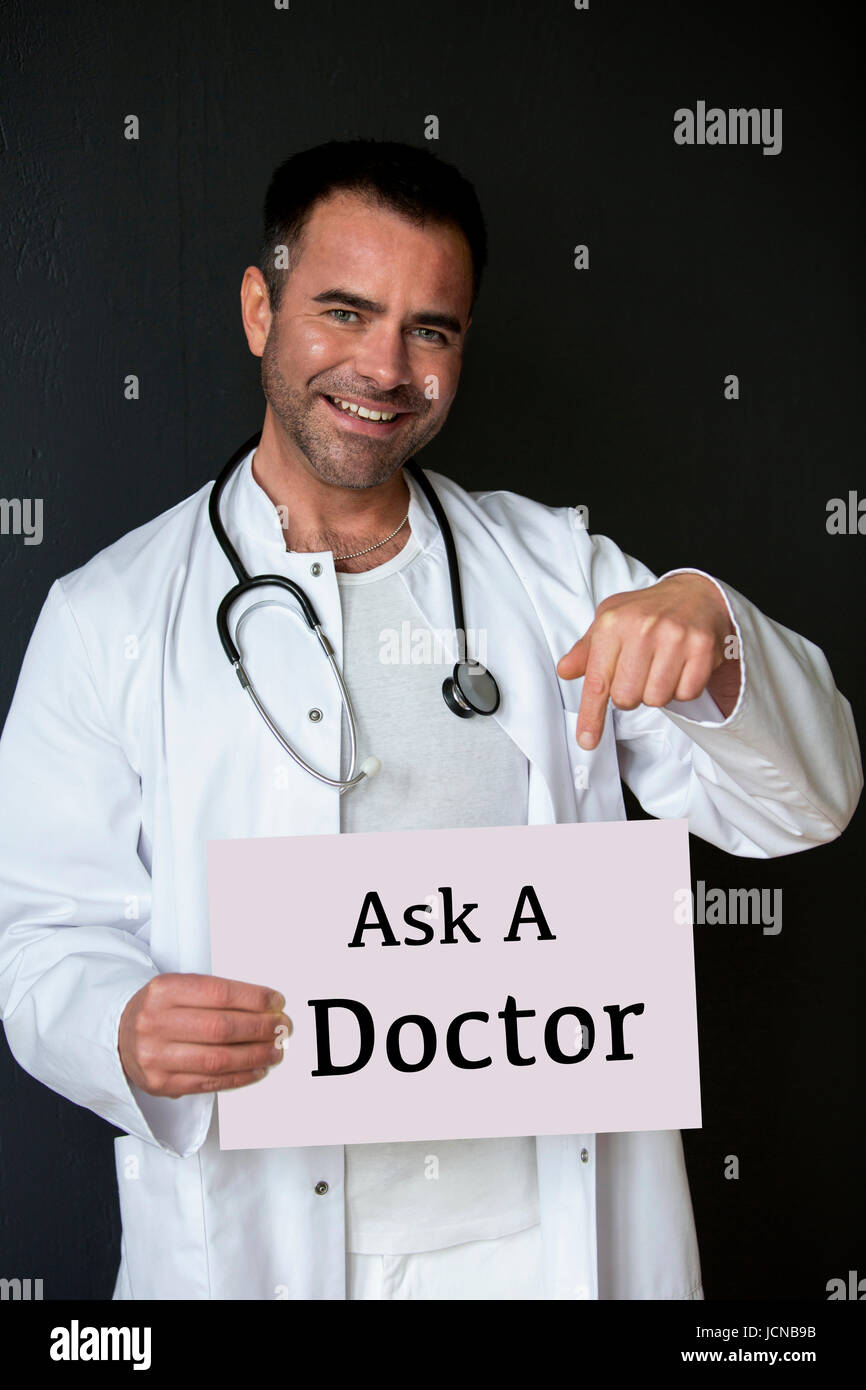 handsome doctor holding a sign with the words Ask A Doctor Stock Photo ...
