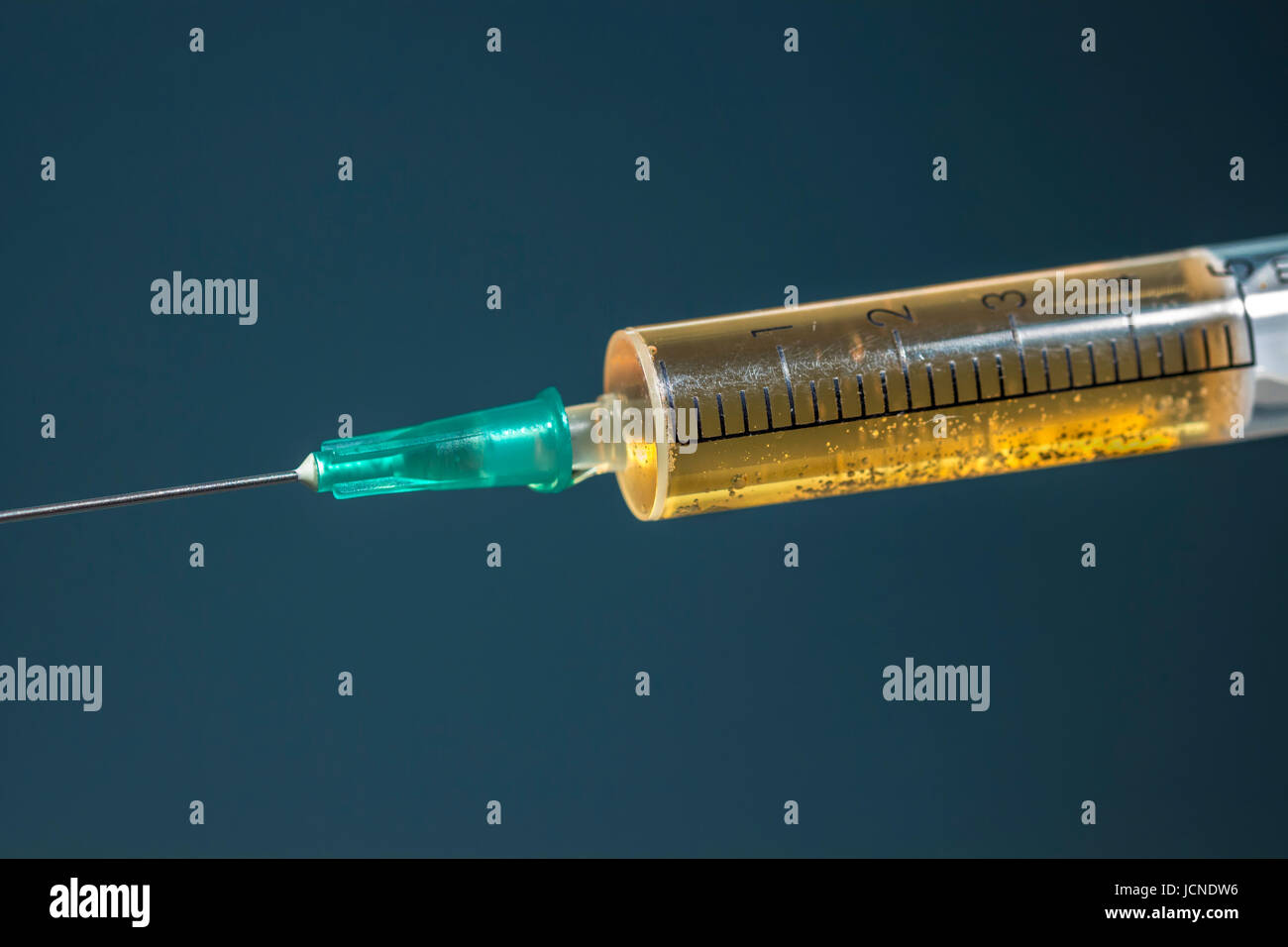 Syringe with a dark yellow drug inside Stock Photo - Alamy