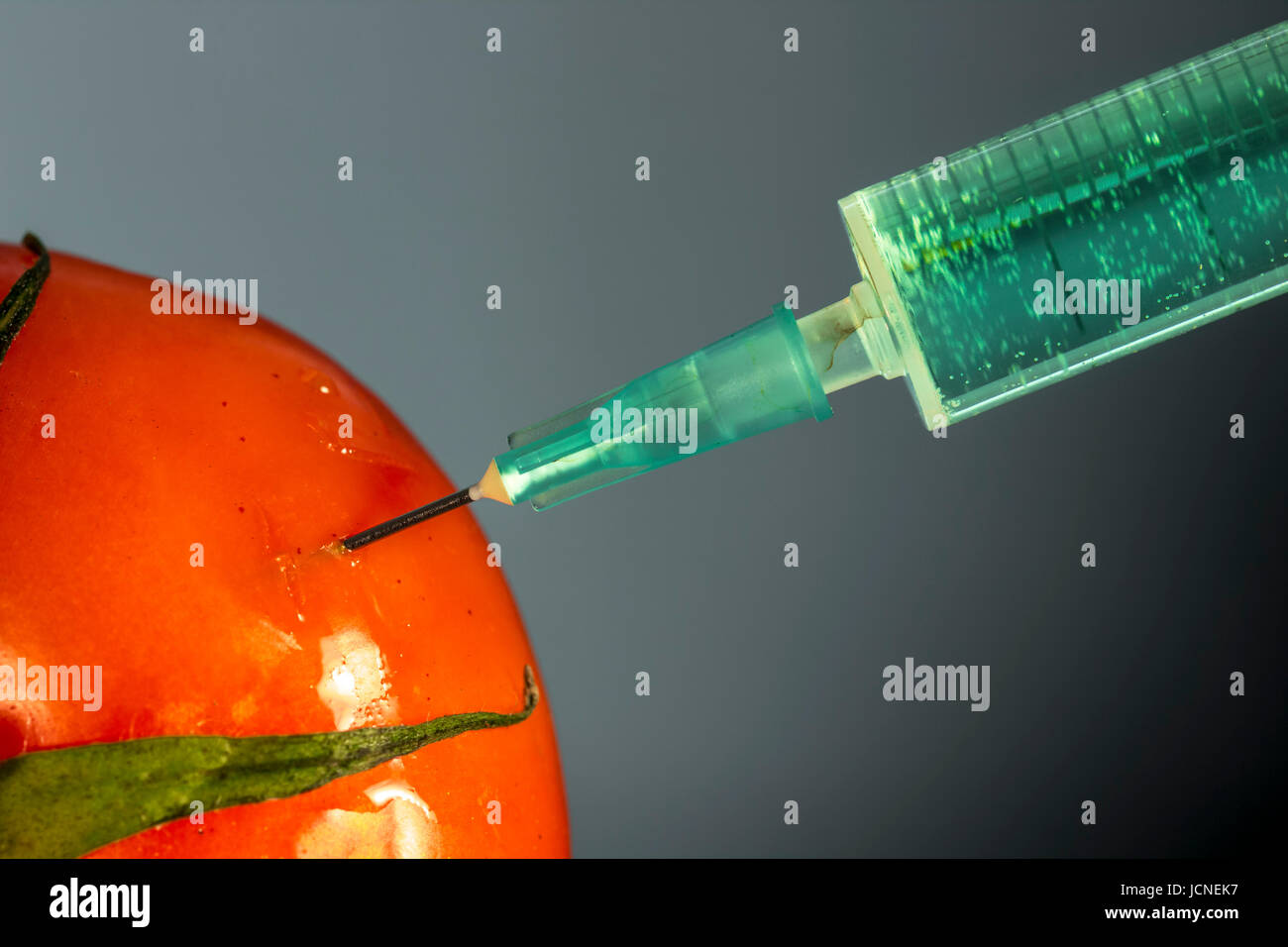 Close-up of hypodermic needle injecting a bright green substance into a ...