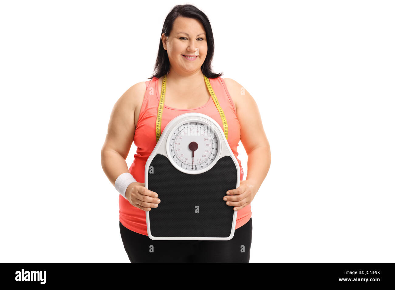 Overweight woman holding a weight scale and looking at the camera ...