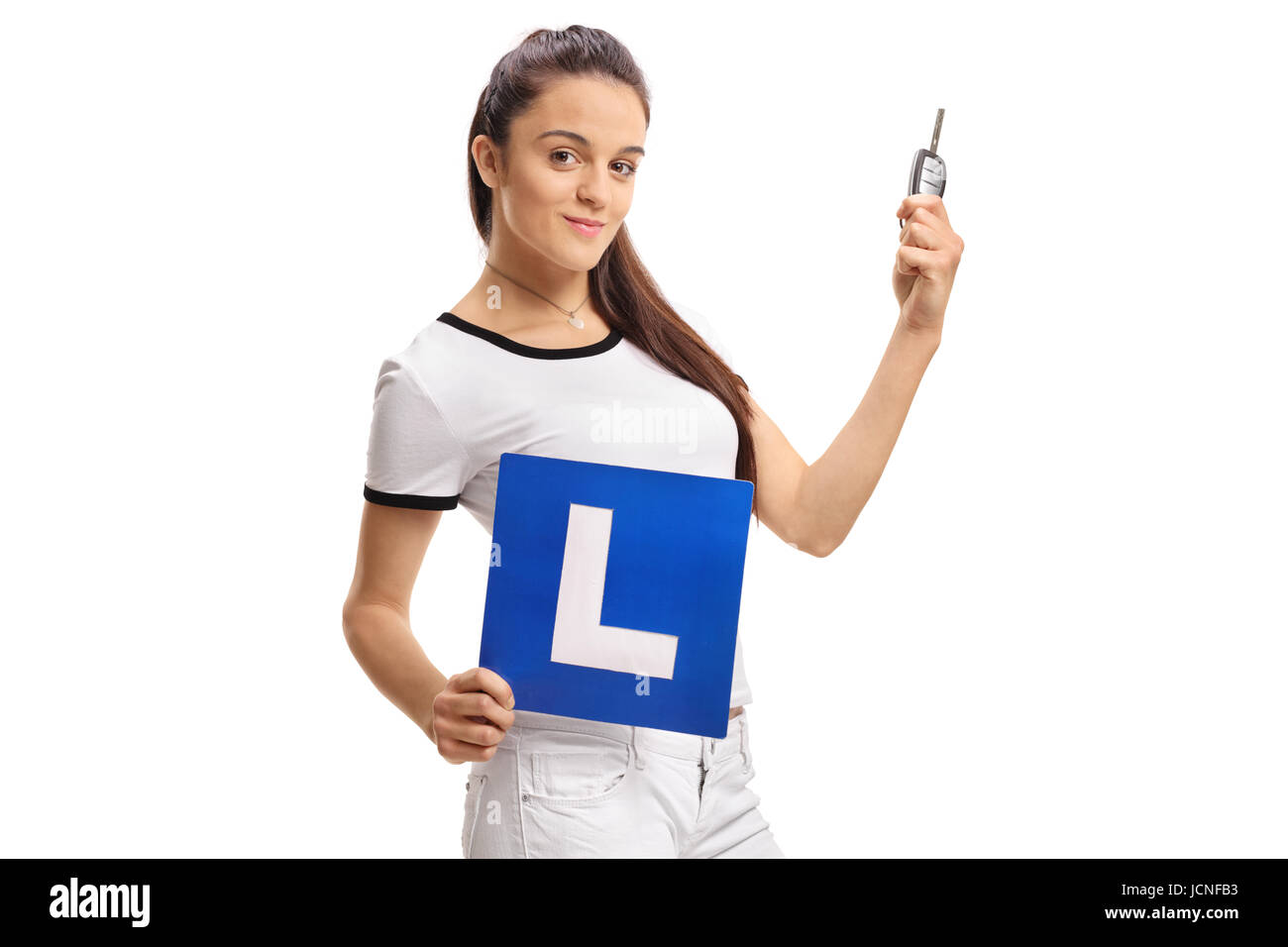 Teenage girl holding a car key and an L-sign isolated on white ...