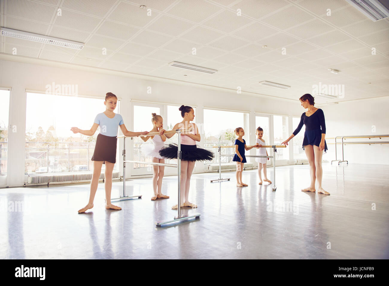 Female teacher practicing with a group of young girls performing a ...