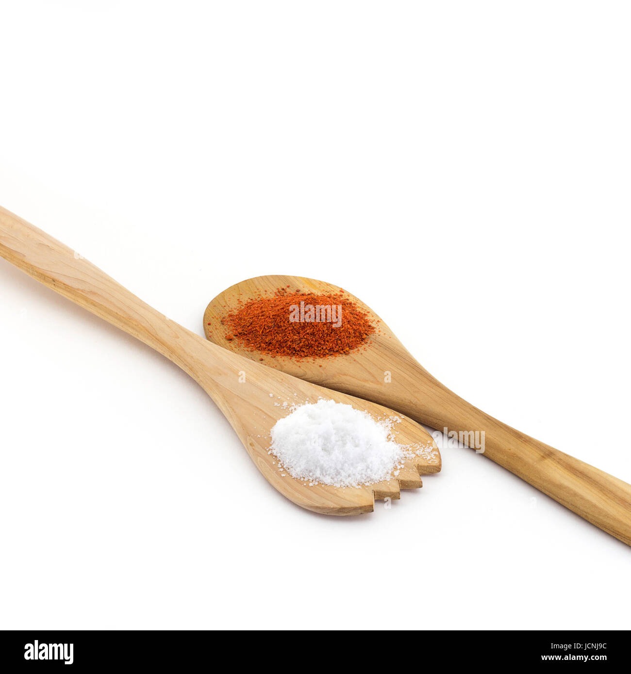 Two royal spices on wooden spoons, salt, black pepper, chilli pepper ...