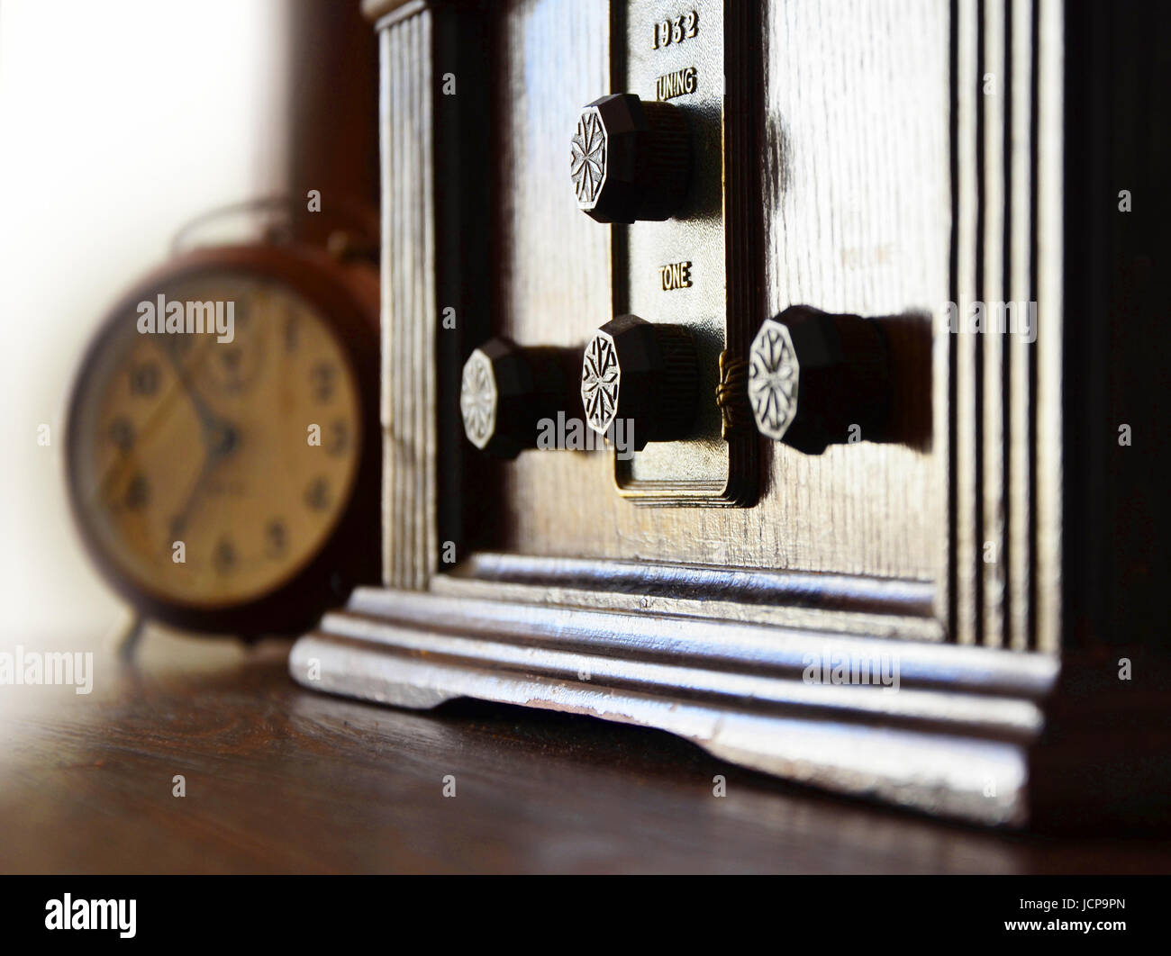 Close up view of antique wooden radio and broken clock with white wall ...