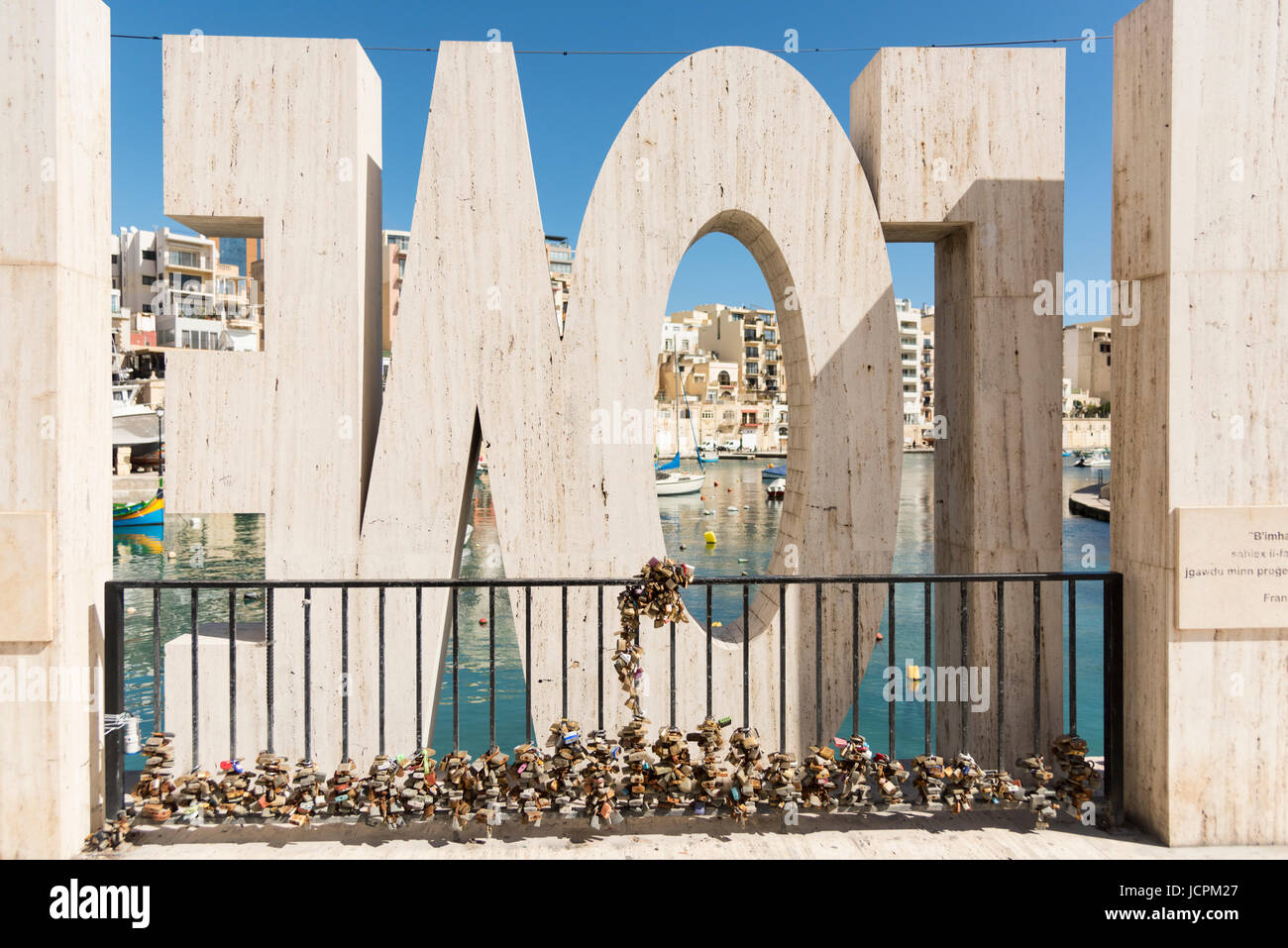A large sign and railings with with lots of love padlocks attached to ...