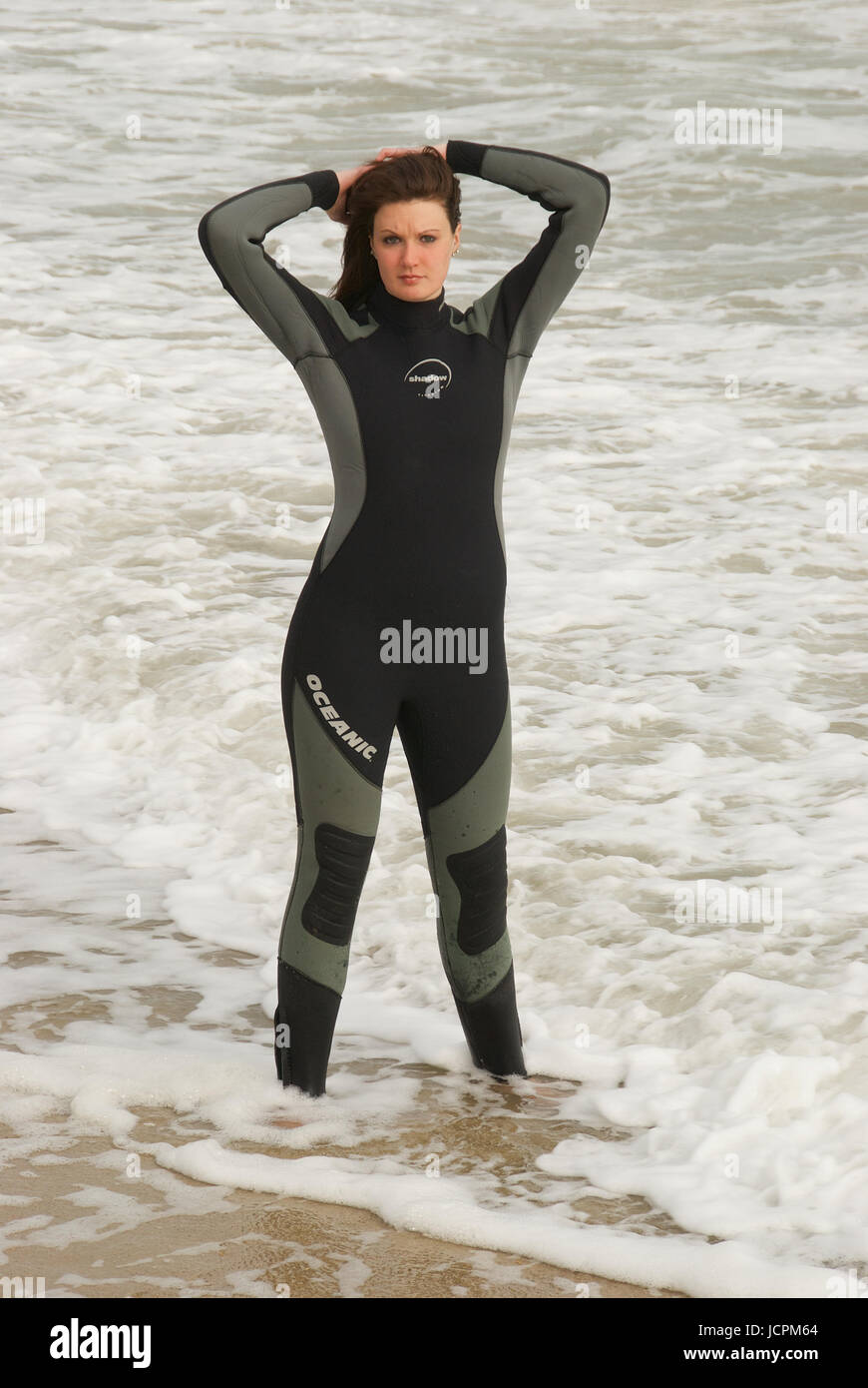 Beautiful brunette girl in wet suit and in the sea Stock Photo - Alamy