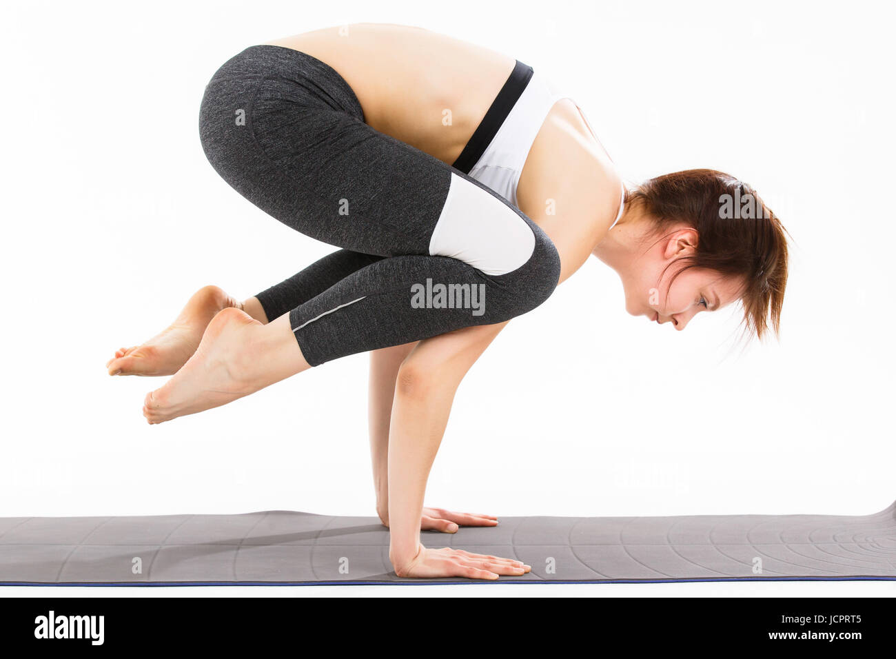 Young woman exercise yoga supported headstand on white Stock Photo - Alamy