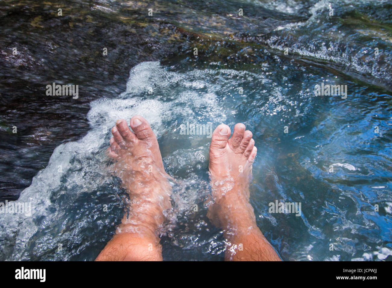Legs relaxing waterfall plunge,wiht waterfall Stock Photo - Alamy