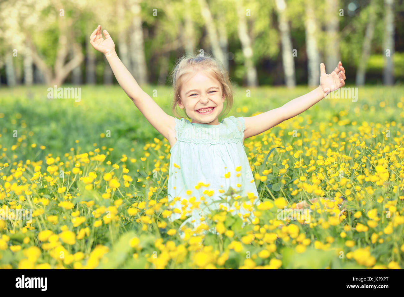 Happy little girl on spring blooming meadow Stock Photo - Alamy