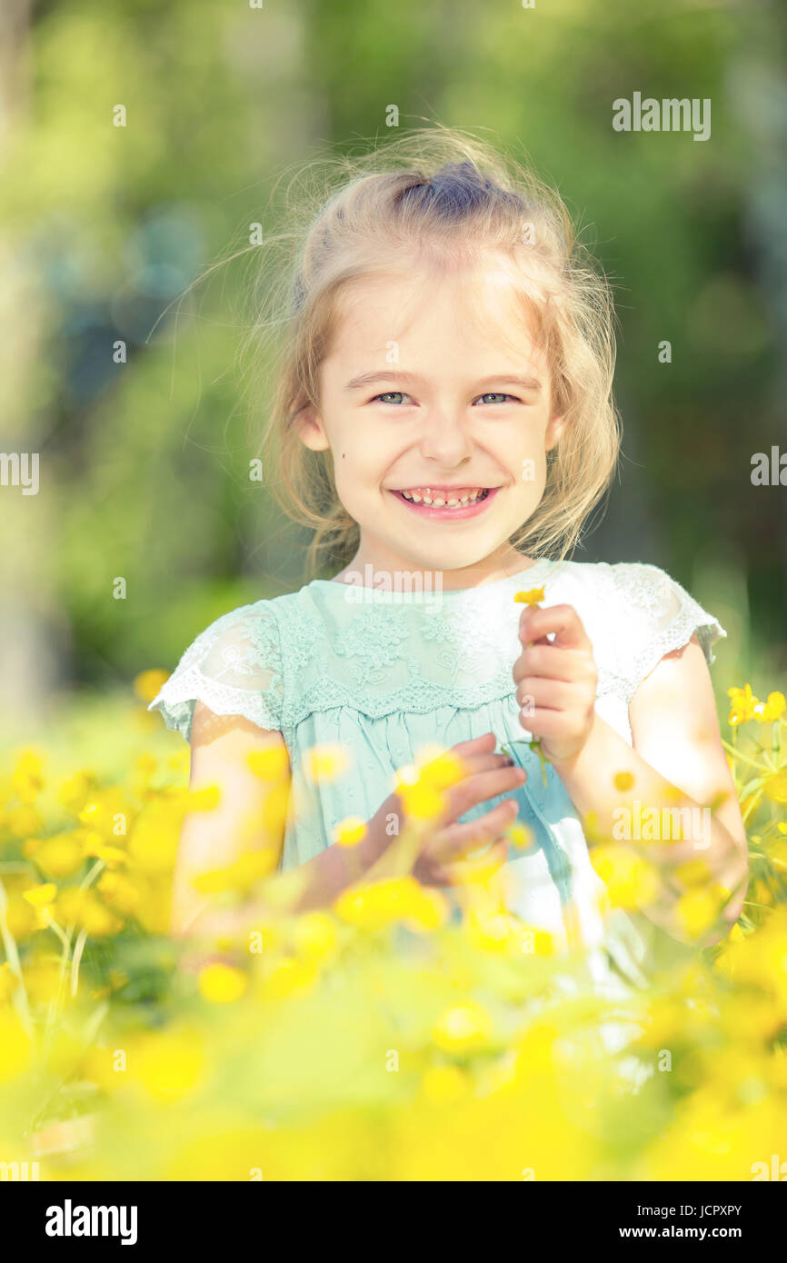 Happy little girl on spring blooming meadow Stock Photo - Alamy