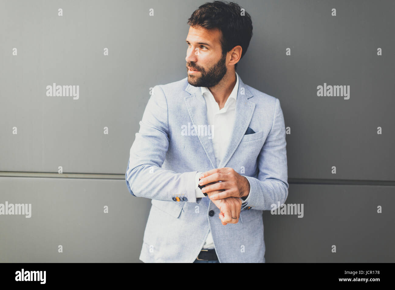 Modern businessman looking at his watch in office Stock Photo - Alamy