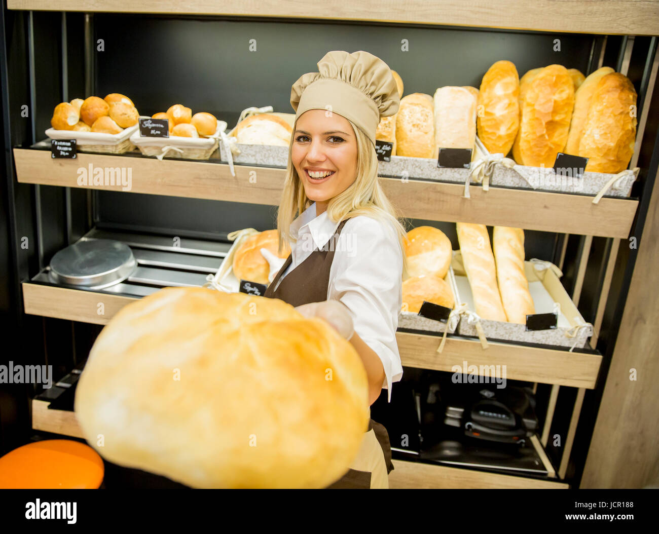 Pretty young woman selling fresh bread in the bakery Stock Photo - Alamy