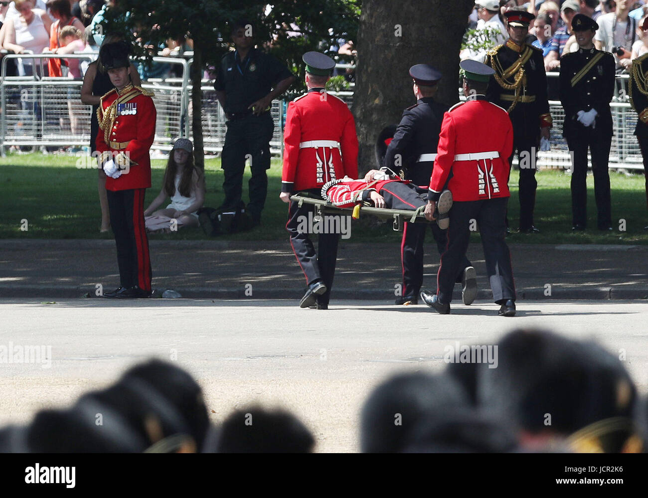 A Guardsman is carried off after fainting during the Trooping the ...