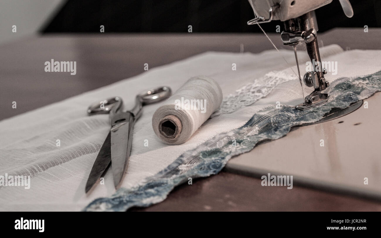 Sewing machine, sewing process, scissors and thread next to machines ...