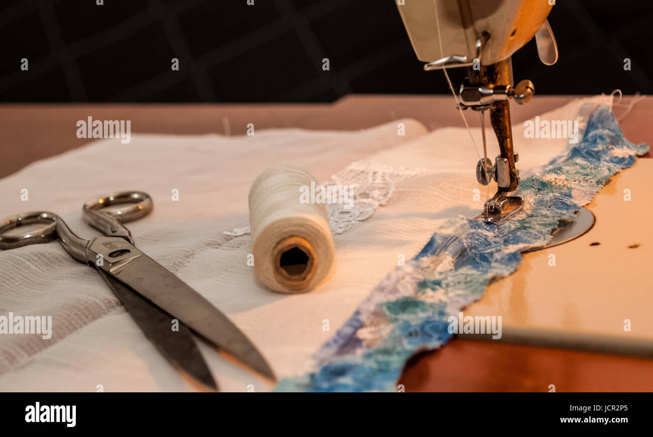 Sewing machine, sewing process, scissors and thread next to machines ...