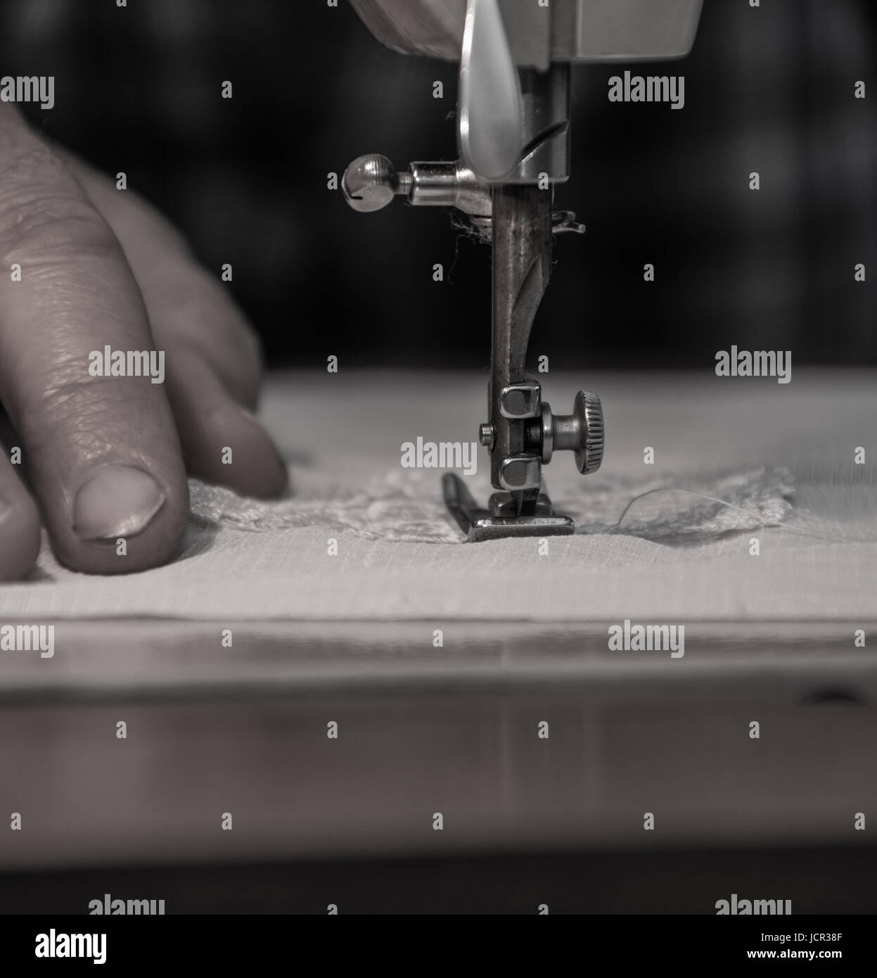 Sewing machine, sewing process, women's hands holding a cloth to sew ...