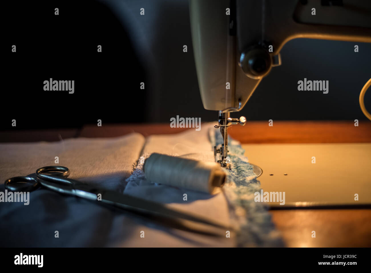 Sewing machine, sewing process, scissors and thread next to machines ...