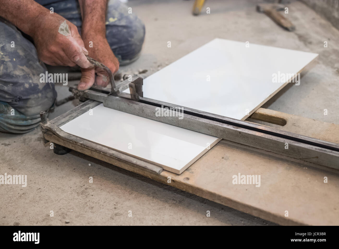 Ceramist cuts tile cutter tile, cut to an appropriate dimension, white ...