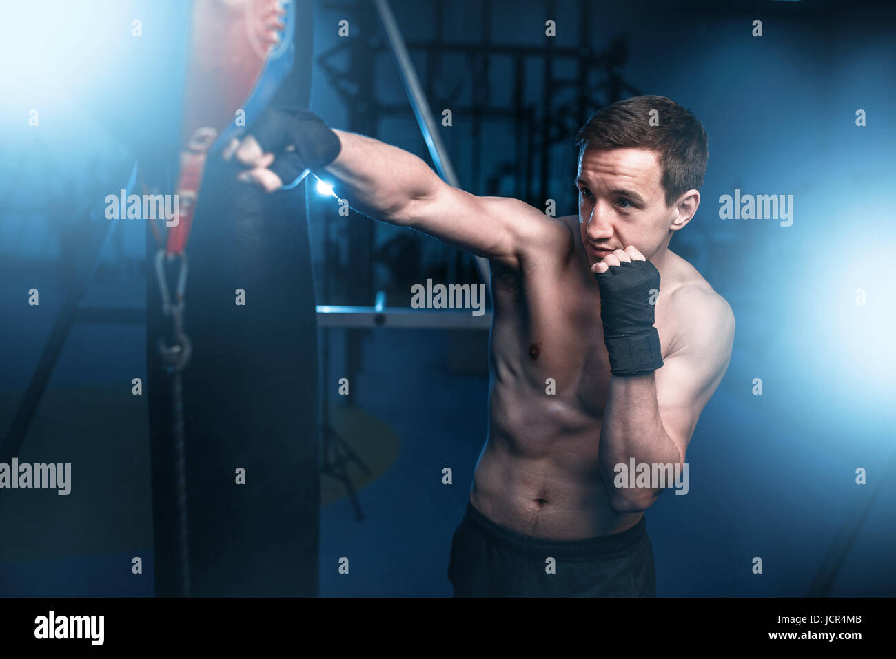 Boxer in bandages training with bag in gym. Boxing workout, mens sport ...