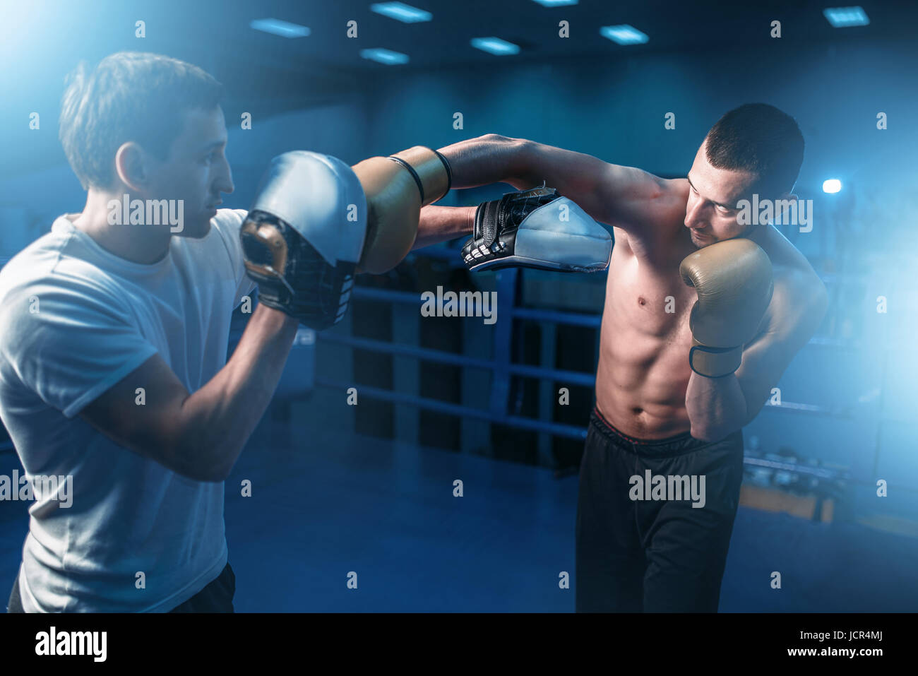 Boxer in gloves exercises with personal trainer. Boxing workout, mens ...