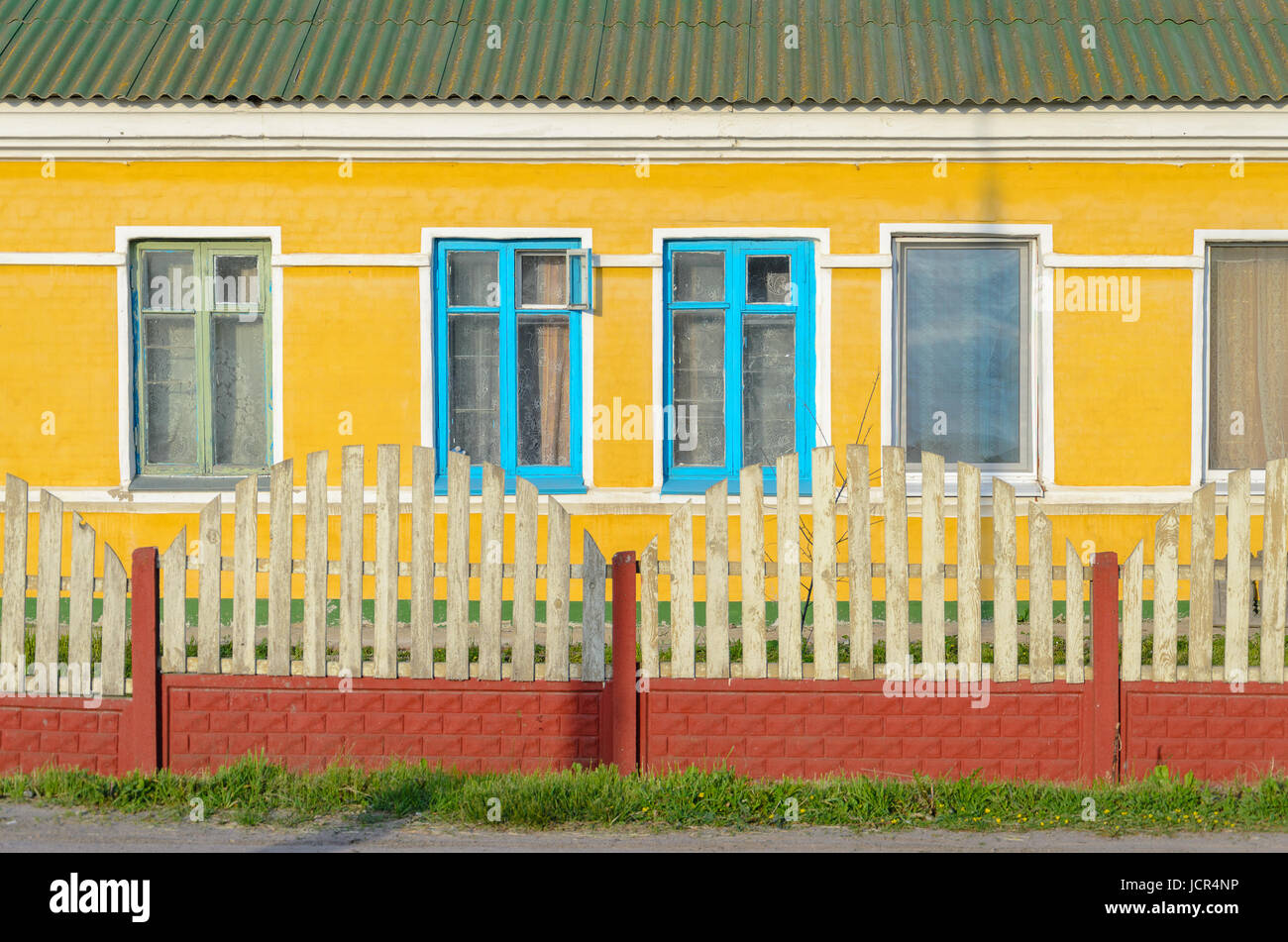 Yellow wall with blue old windows frames. Yellow facade of private ...