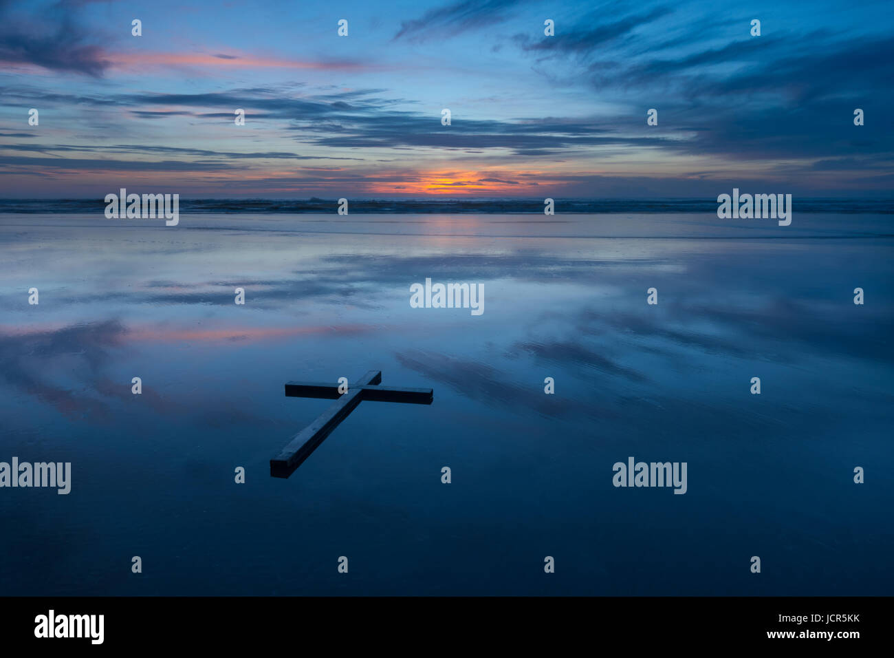 Cross lay down on a flat reflection beach at sunset Stock Photo - Alamy