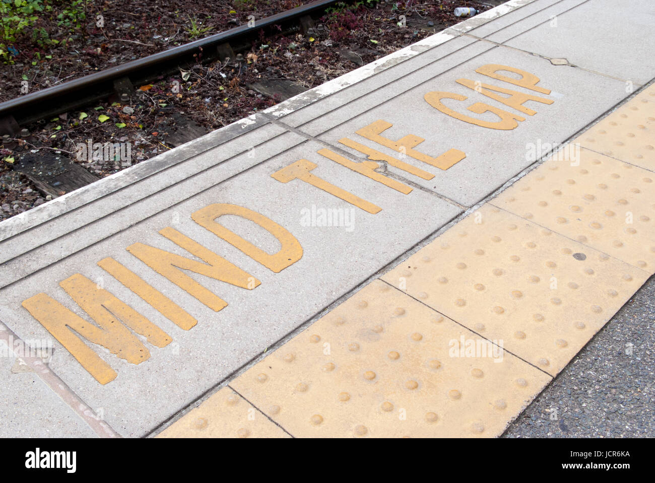Platform edge at the train station with safety warning Stock Photo - Alamy